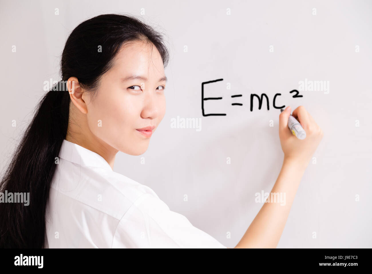 Chinese high school girl in uniform writing on whiteboard Stock Photo ...