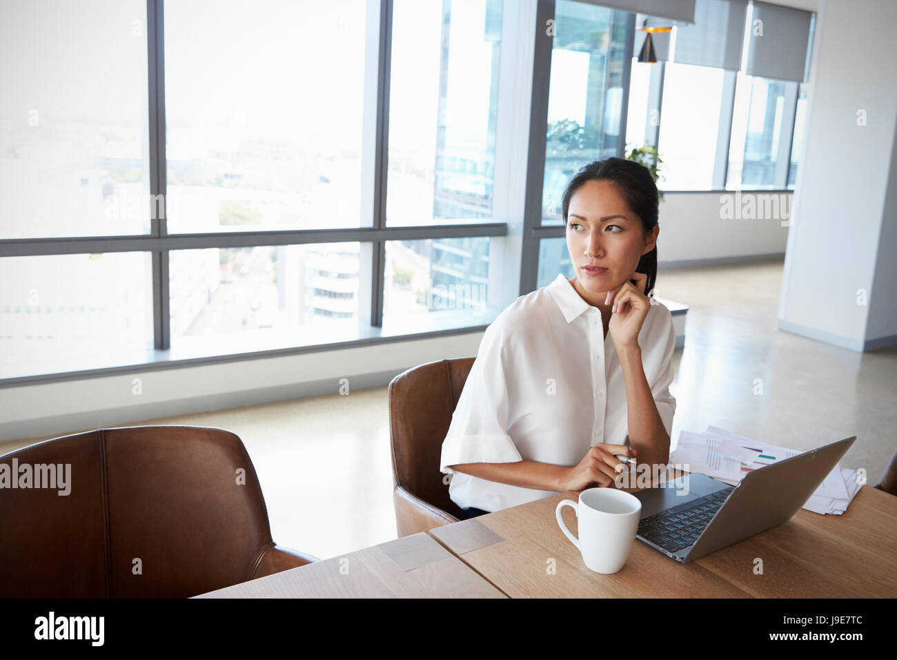 Businesswoman Working Alone On Laptop In Office Boardroom Stock Photo ...