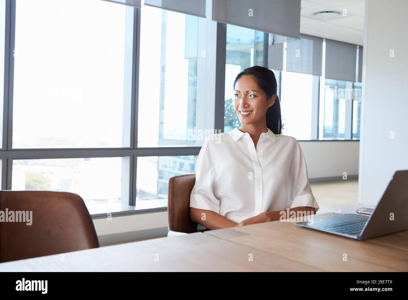Businesswoman Working Alone On Laptop In Office Boardroom Stock Photo ...