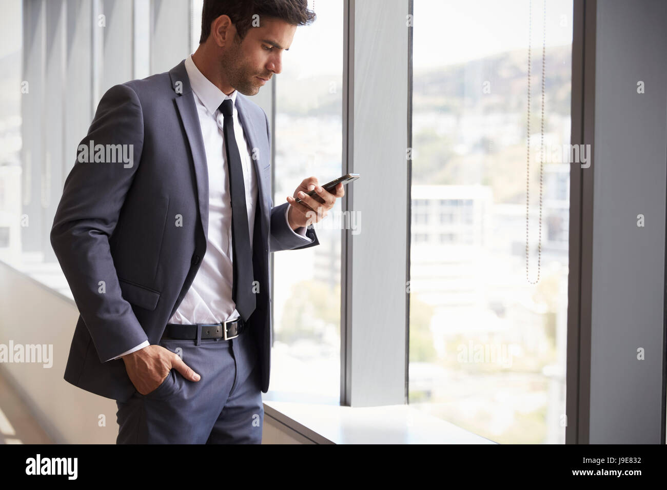 Businessman Checking Messages On Mobile Phone Stock Photo - Alamy