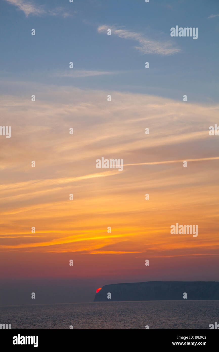 Sun Disappearing behind Cliff at Sunset Stock Photo - Alamy