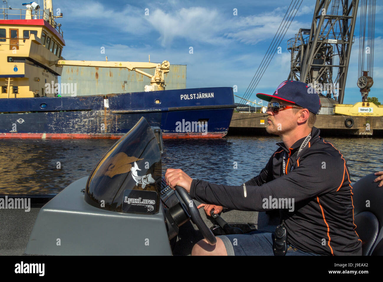 Boat driving through the harbour Stock Photo - Alamy