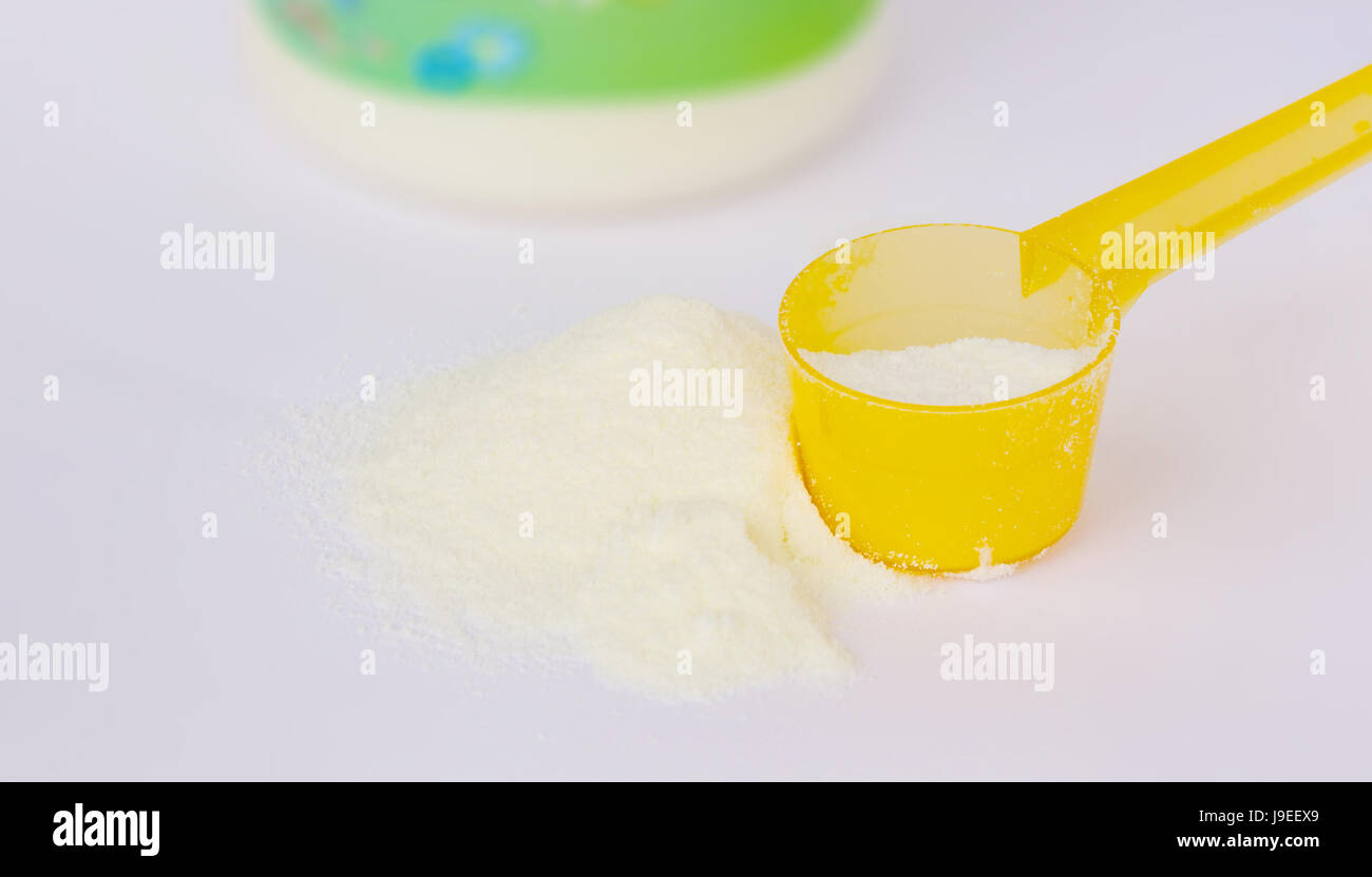 Artificial powder milk for babies. Measuring spoon and a plastic bottle ...