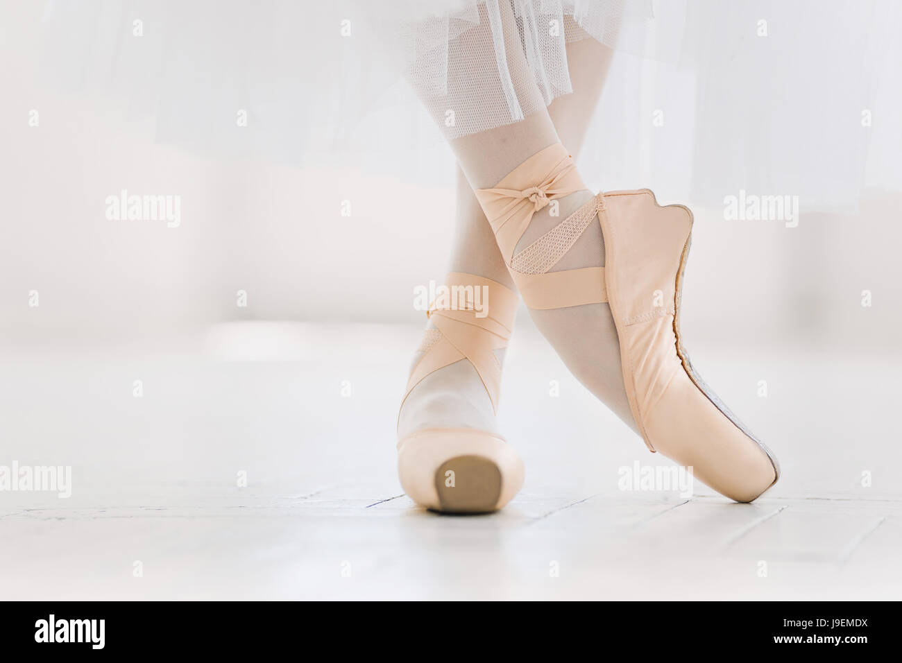 Young ballerina, closeup on legs and shoes, standing in pointe position ...