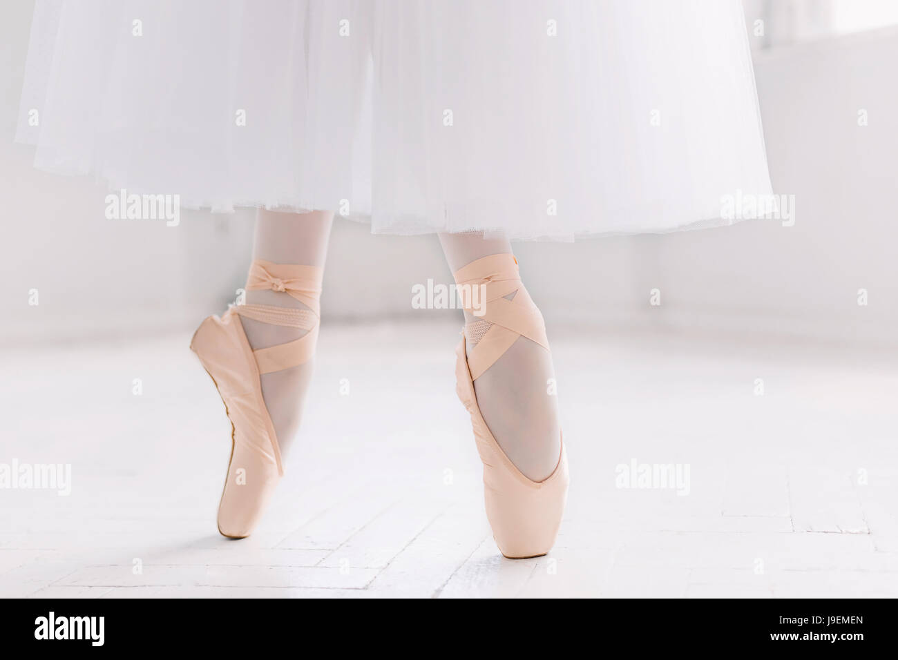 Young ballerina, closeup on legs and shoes, standing in pointe position ...