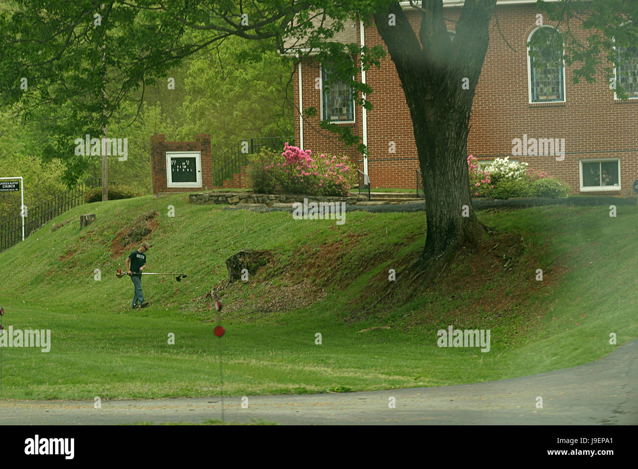Young boy mowing grass in church yard Stock Photo - Alamy