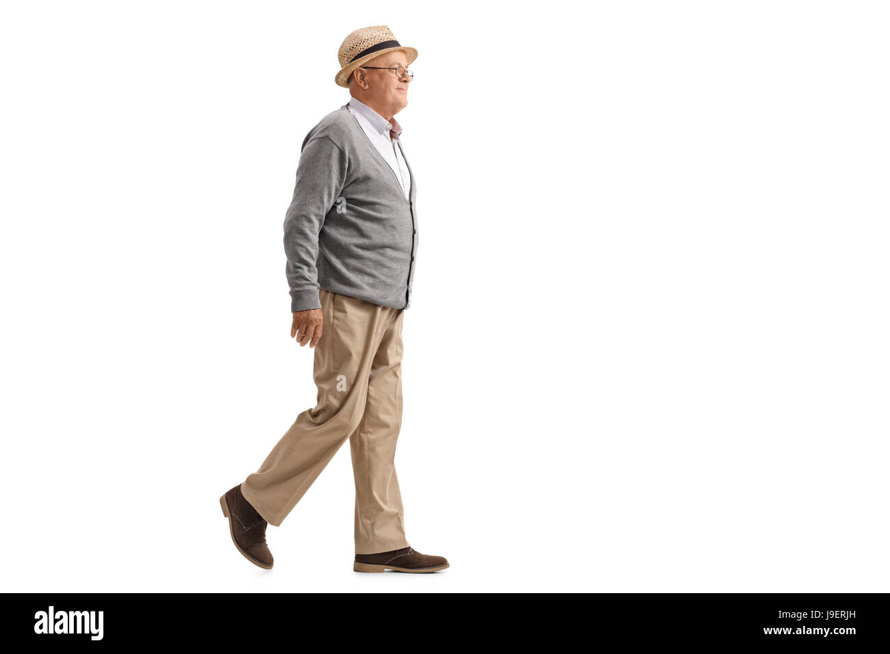 Full length profile shot of an elderly man walking and smiling isolated ...