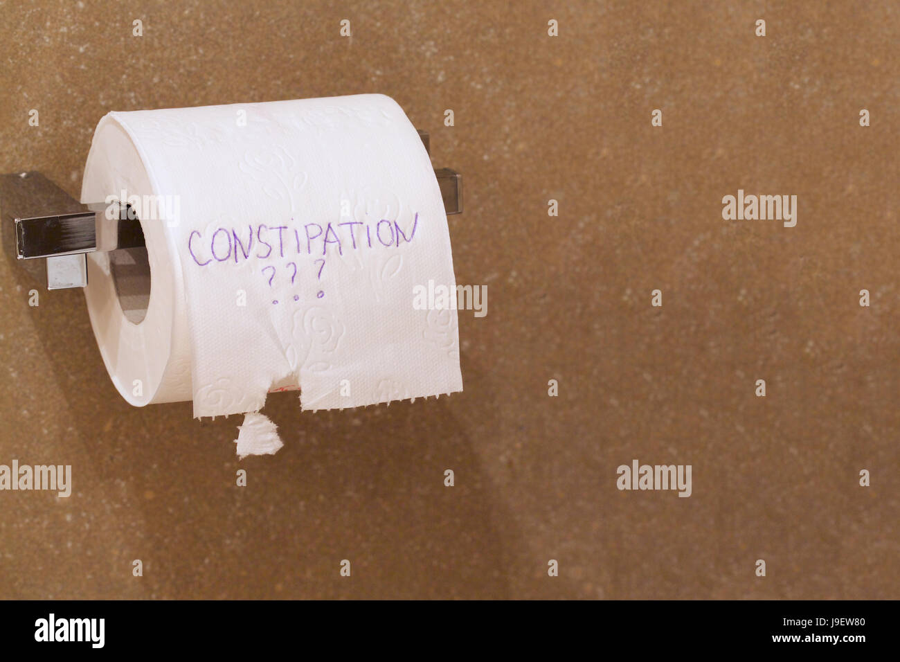 The word constipation and question mark is written on a roll of white ...