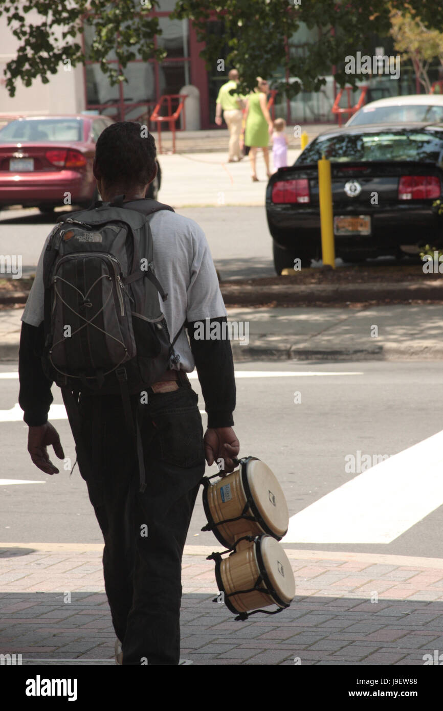 Man with African drum walking on city street Stock Photo - Alamy
