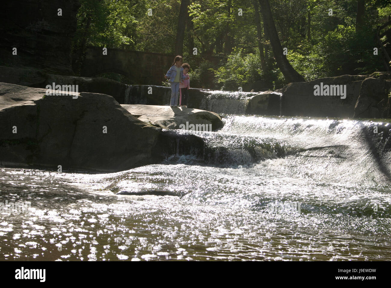Two little girls alone near waterfall Stock Photo - Alamy
