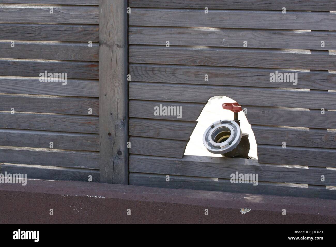 One-way fire hydrant valve in the wooden fence Stock Photo - Alamy