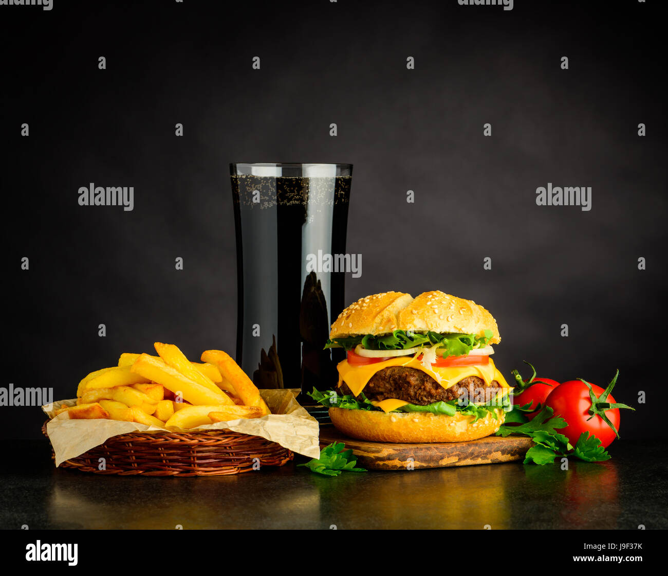 Tasty Looking Cheeseburger with Cola and French Fries on Dark ...