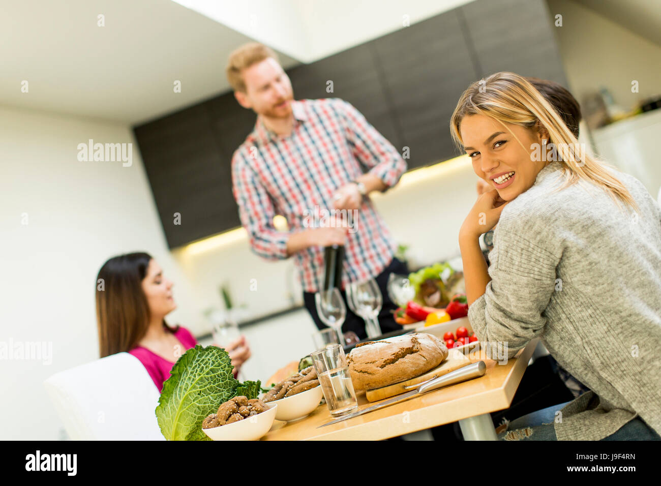 View at young people have a meal in the dining room in modern home ...