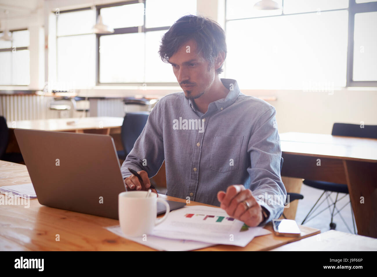 Mid-adult white man working in an office using laptop Stock Photo - Alamy