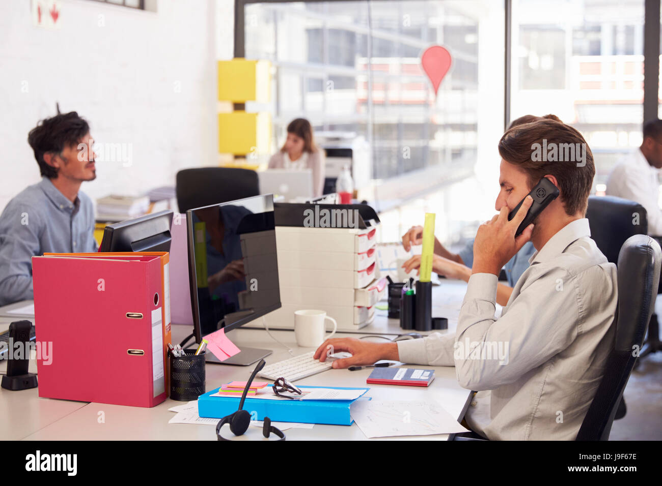 Young business team working in a busy open plan office Stock Photo - Alamy