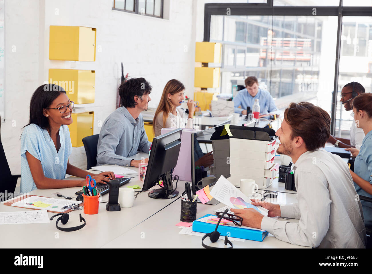 Happy young business team working in a busy open plan office Stock ...