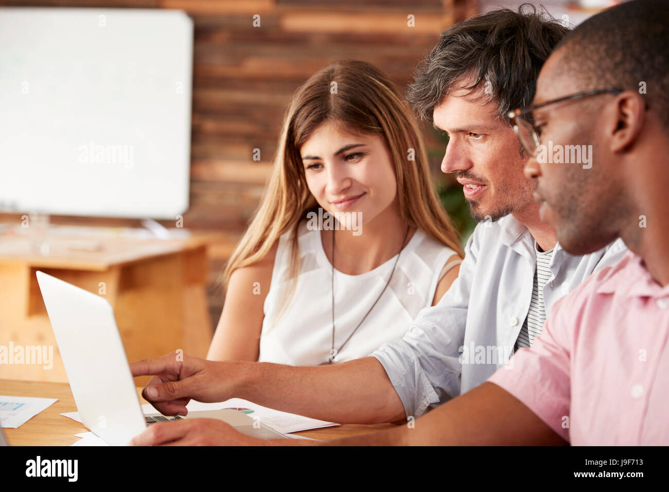 Three colleagues work together at laptop computer, close up Stock Photo ...