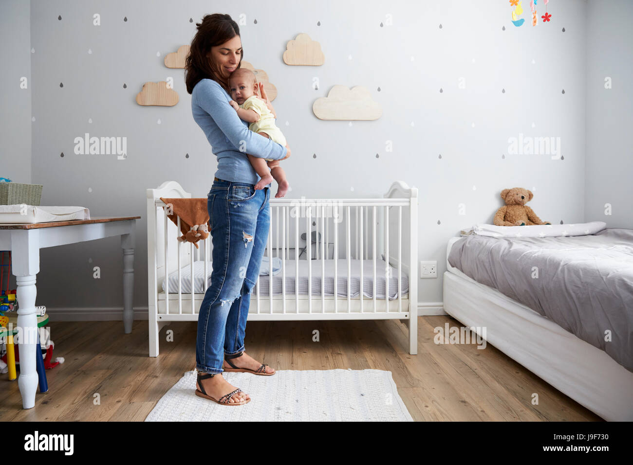 Mother Comforting Newborn Baby Son In Nursery Stock Photo - Alamy