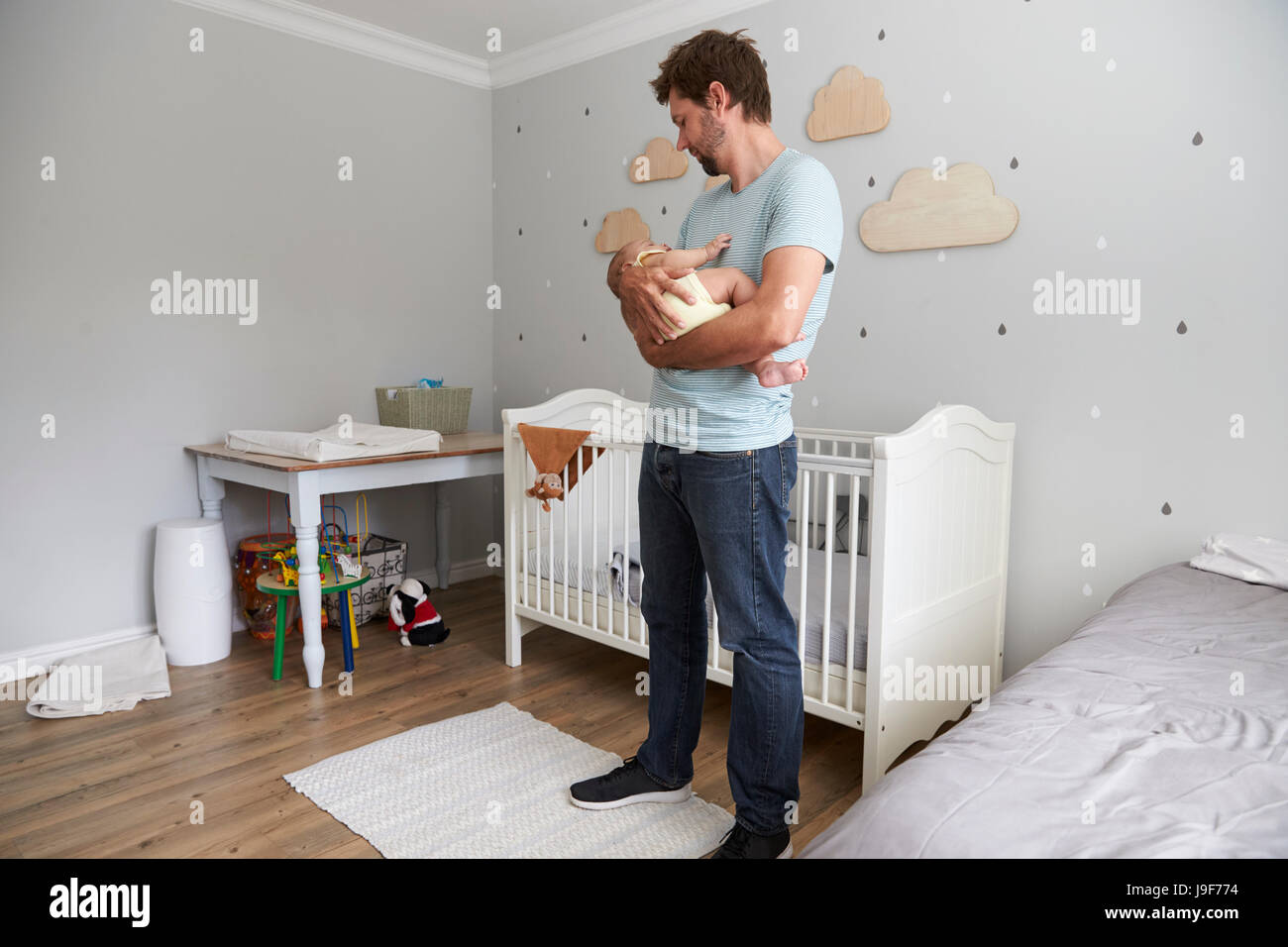 Father Comforting Newborn Baby Son In Nursery Stock Photo - Alamy