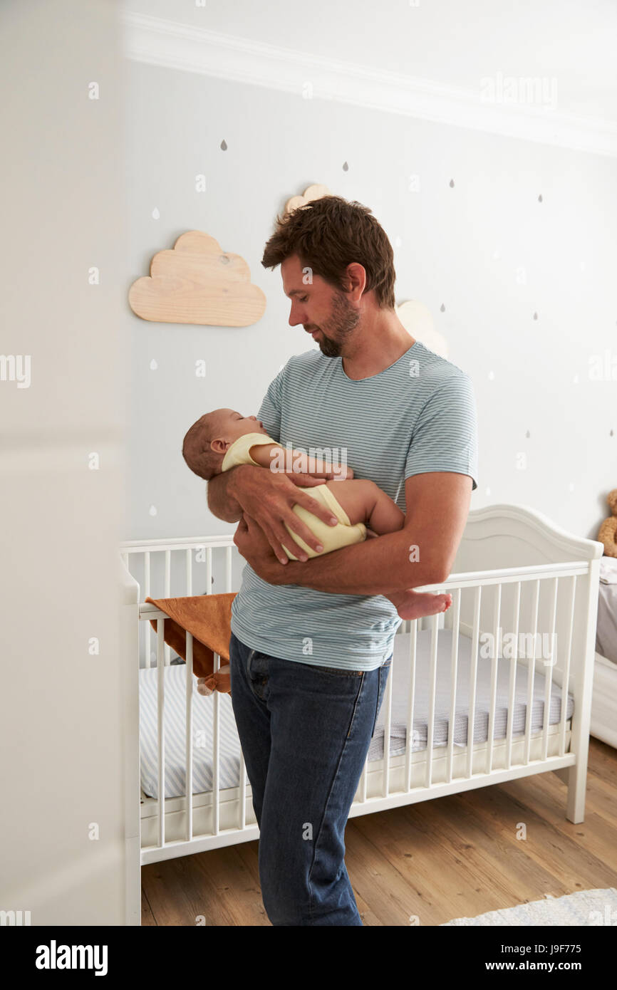 Father Comforting Newborn Baby Son In Nursery Stock Photo - Alamy