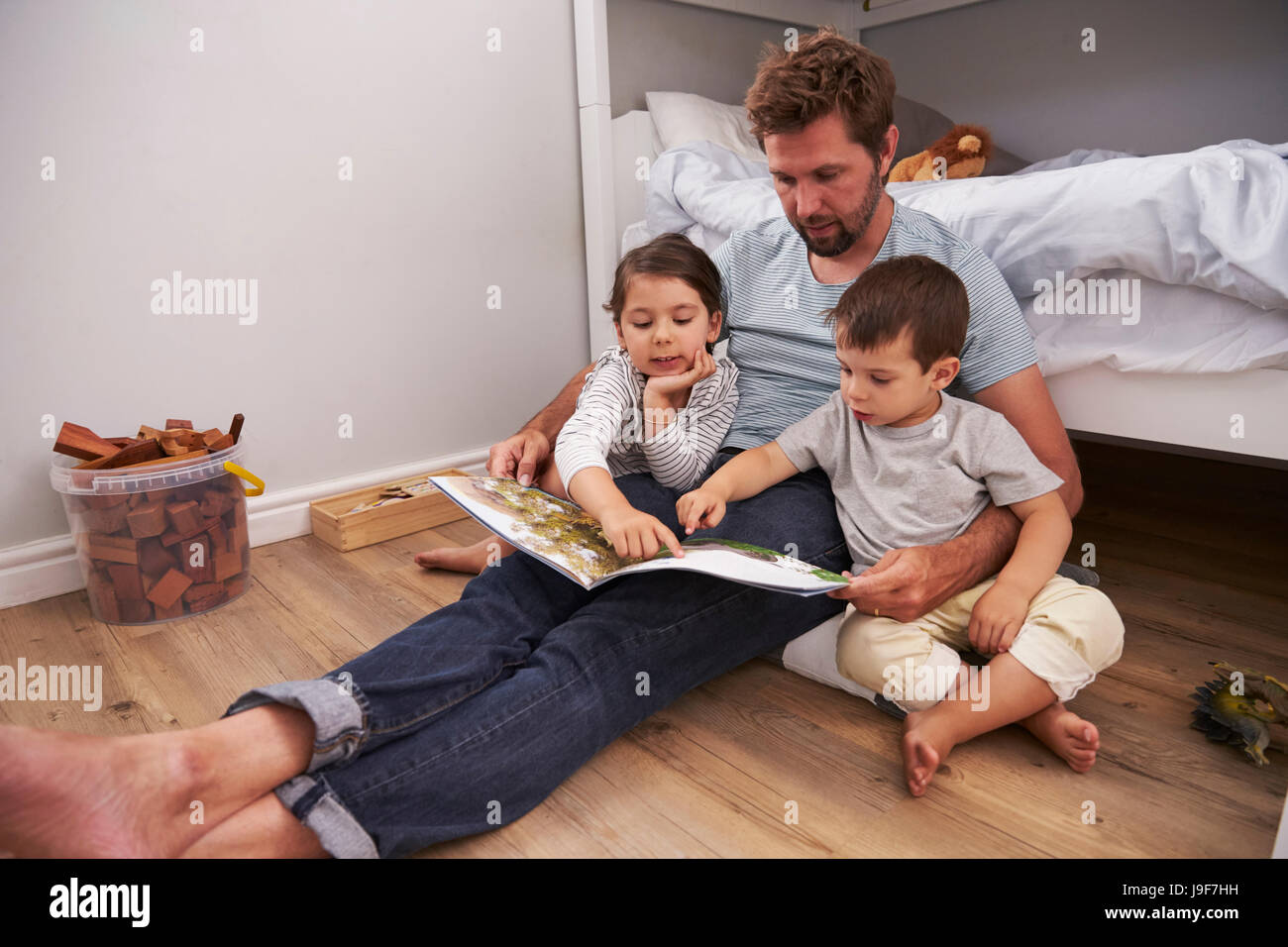 Father Reading Story To Children In Their Bedroom Stock Photo - Alamy