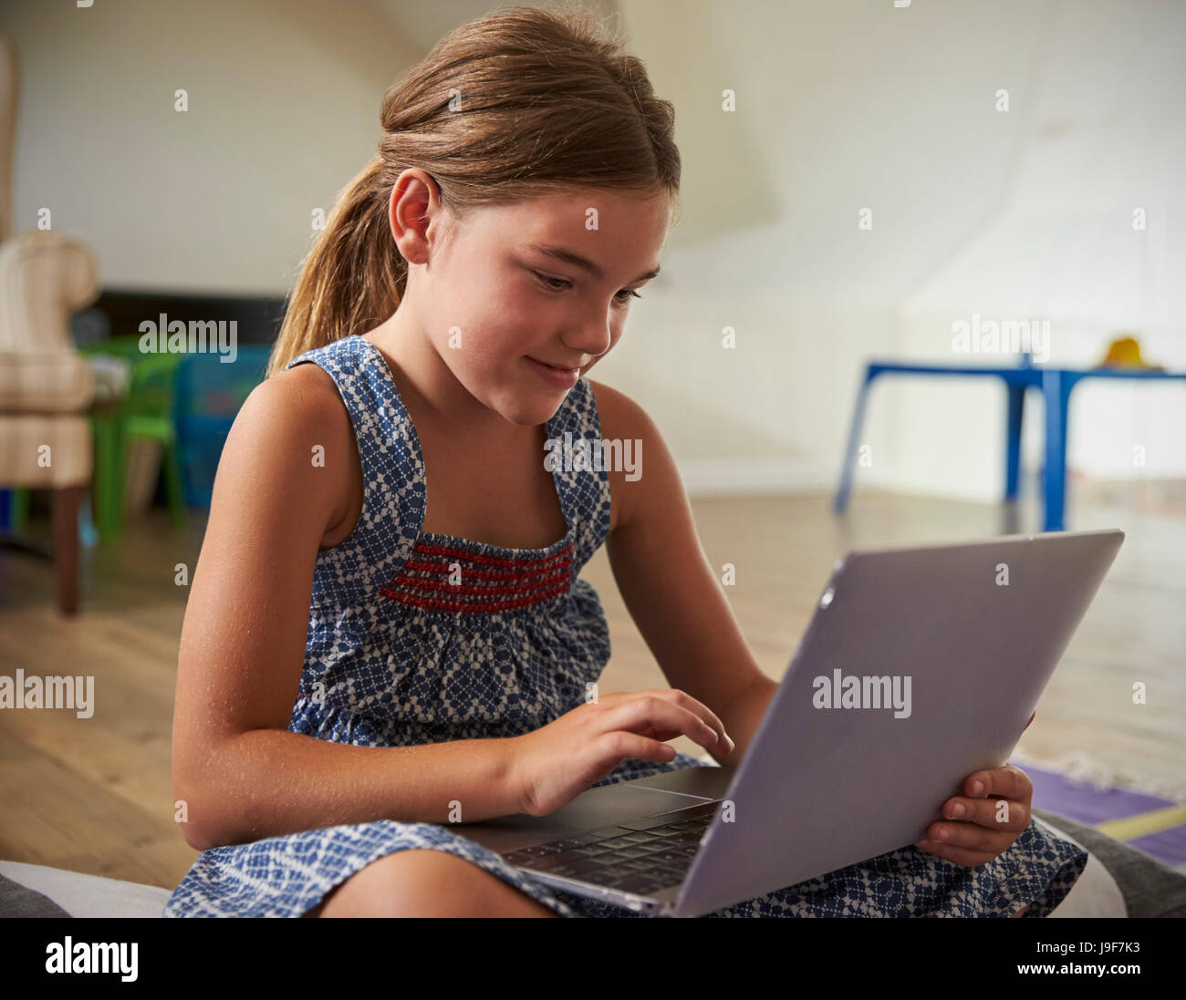 Girl Using Laptop Computer In Playroom Stock Photo - Alamy