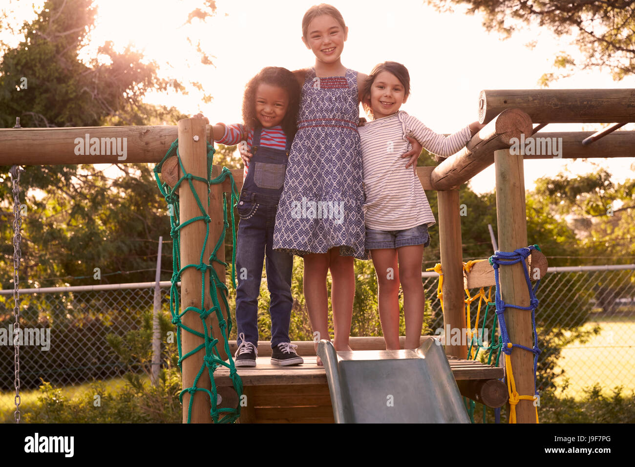 Three Girls Playing Outdoors At Home On Garden Slide Stock Photo - Alamy