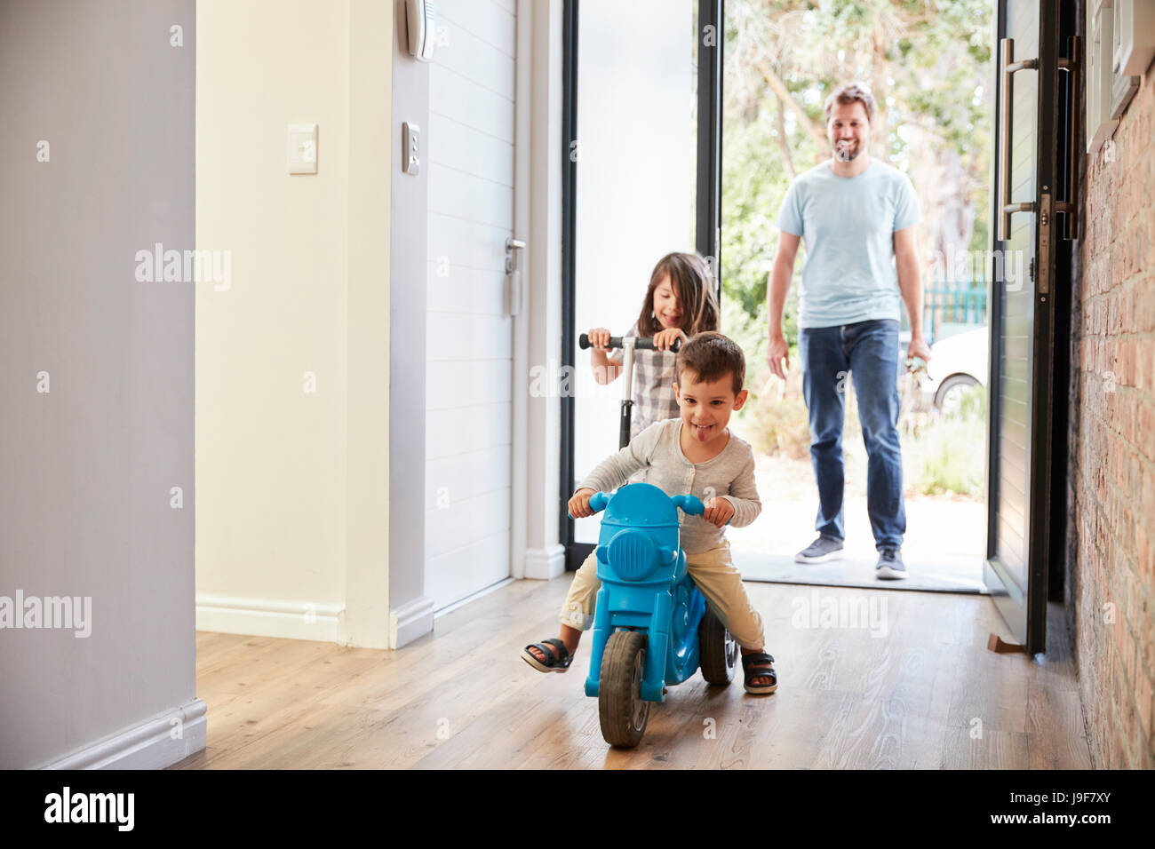 Excited Children Arriving Home With Father Stock Photo - Alamy