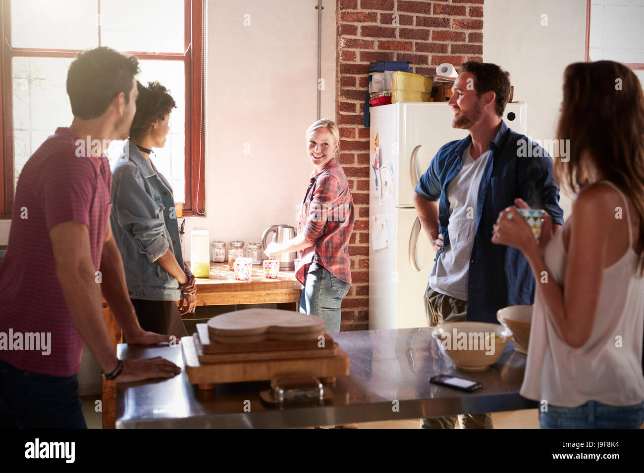 Five friends talk standing in kitchen, close up Stock Photo - Alamy