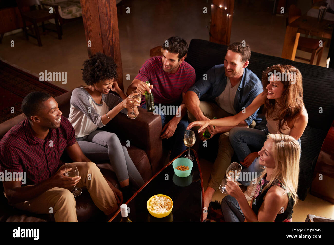 Young adults socialising at a party at home, elevated view Stock Photo ...