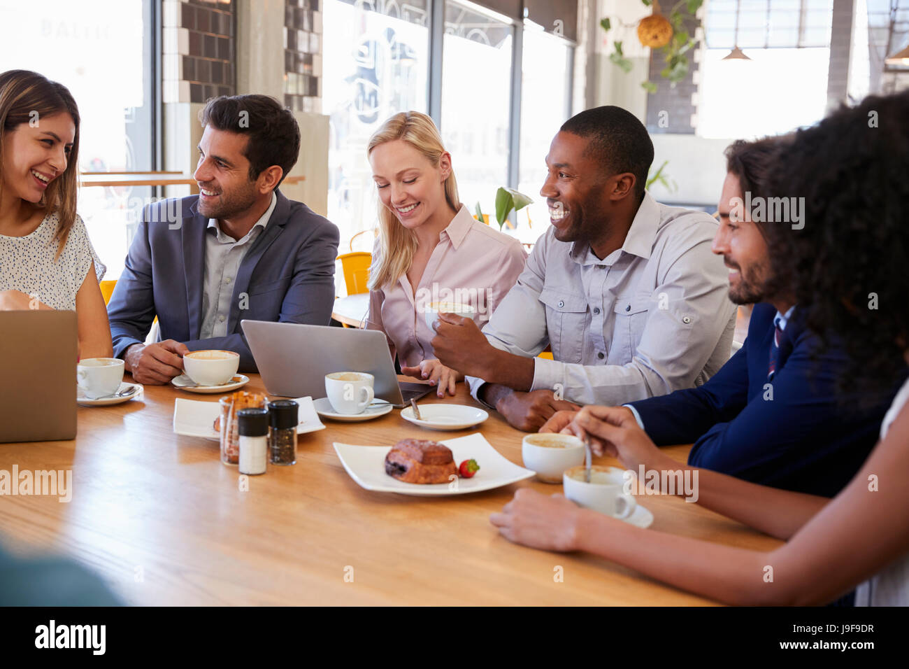 Group Of Businesspeople Having Meeting In Coffee Shop Stock Photo - Alamy