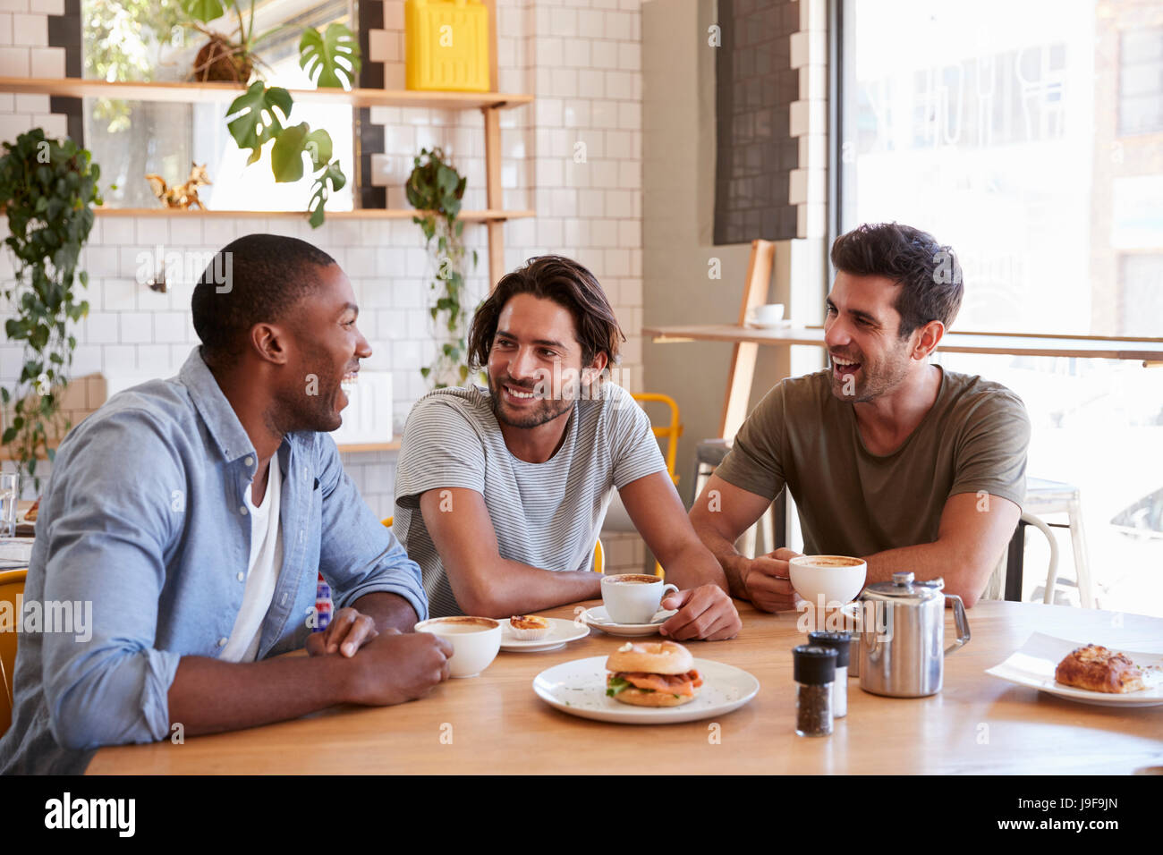 Three Male Friends Meeting For Lunch In Coffee Shop Stock Photo - Alamy