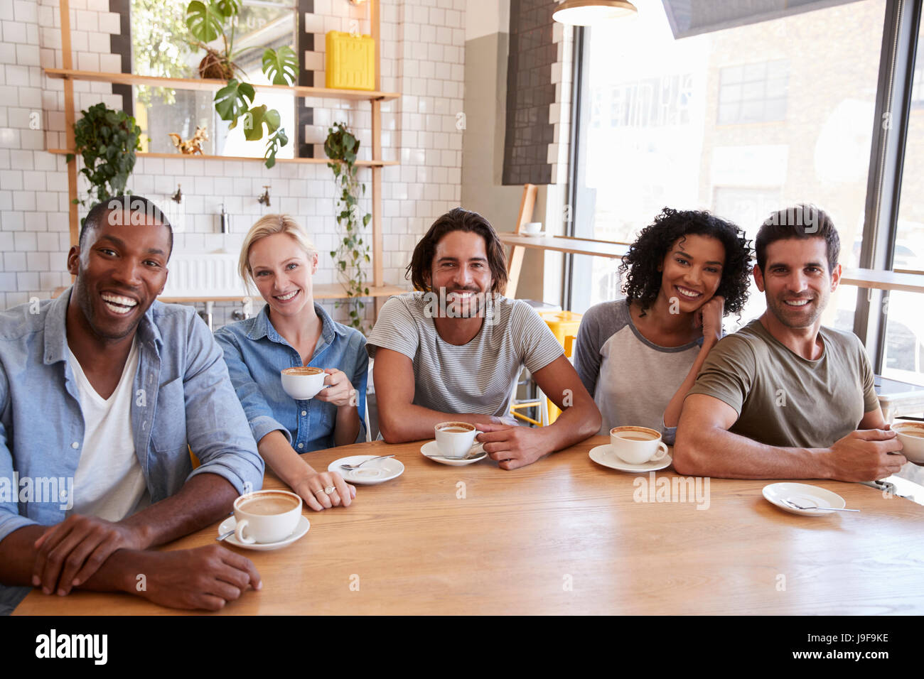 Portrait Of Friends Meeting Around Table In Coffee Shop Stock Photo - Alamy