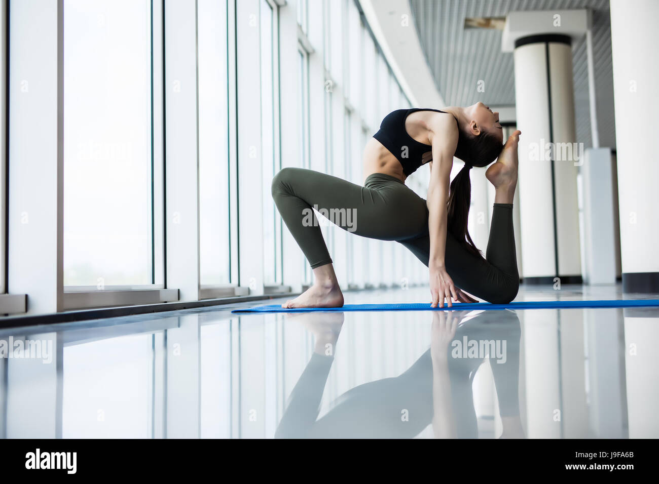 woman yoga make exercises in big hall with big panoramic windows Stock ...
