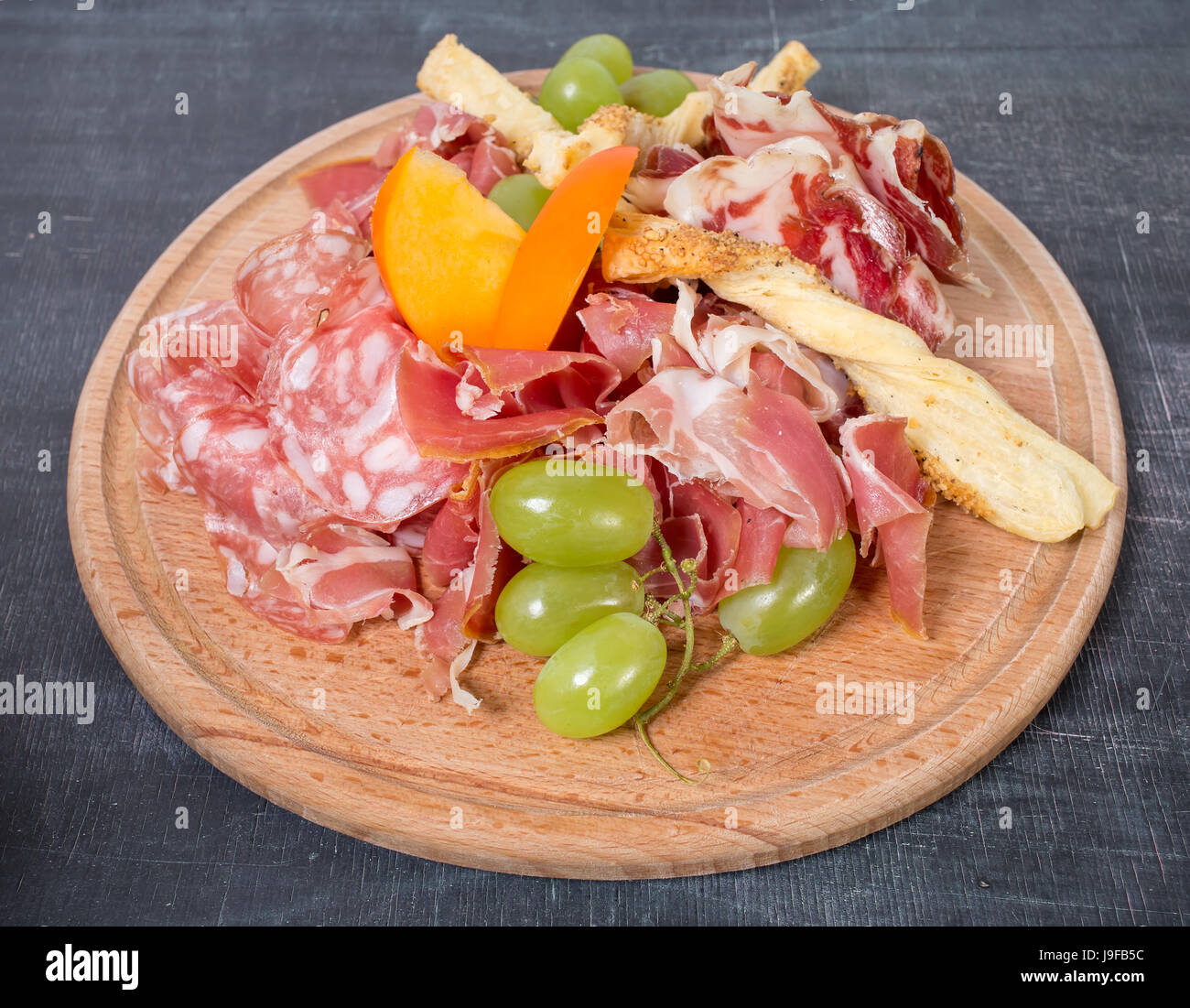Mixed italian dried meats platter with croutons and grapes. Plate ...
