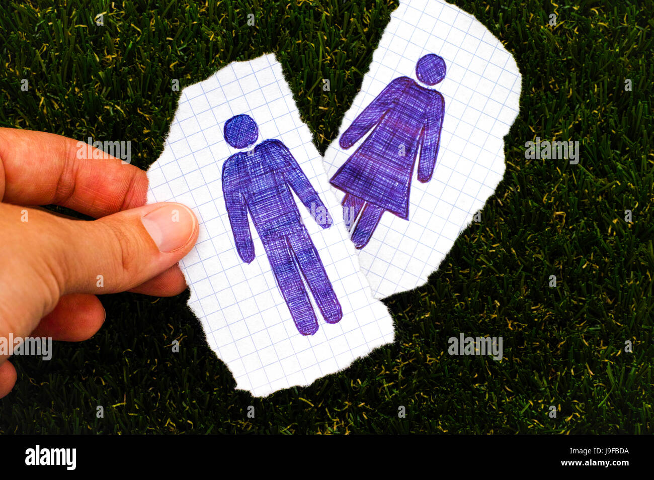 Person fingers holding piece of paper with hand drawn man figure. Other ...