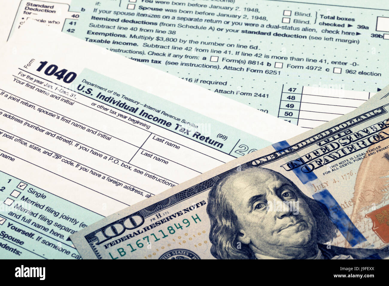 US 1040 Tax Form and dollars - studio shot. Filtered image: cross ...
