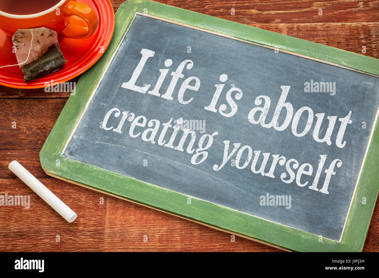 Life is about creating yourself - motivational text on a slate ...
