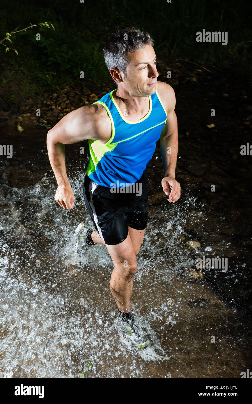 jogger traverses streambed Stock Photo - Alamy