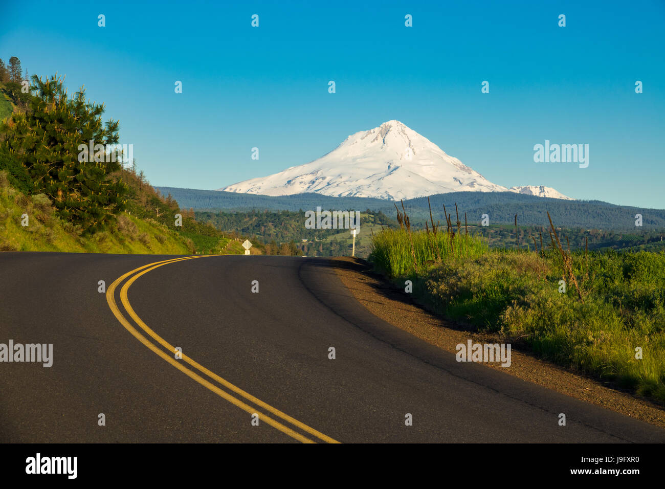 Eastern side of Mount Hood rising above a highway in Oregon Stock Photo ...