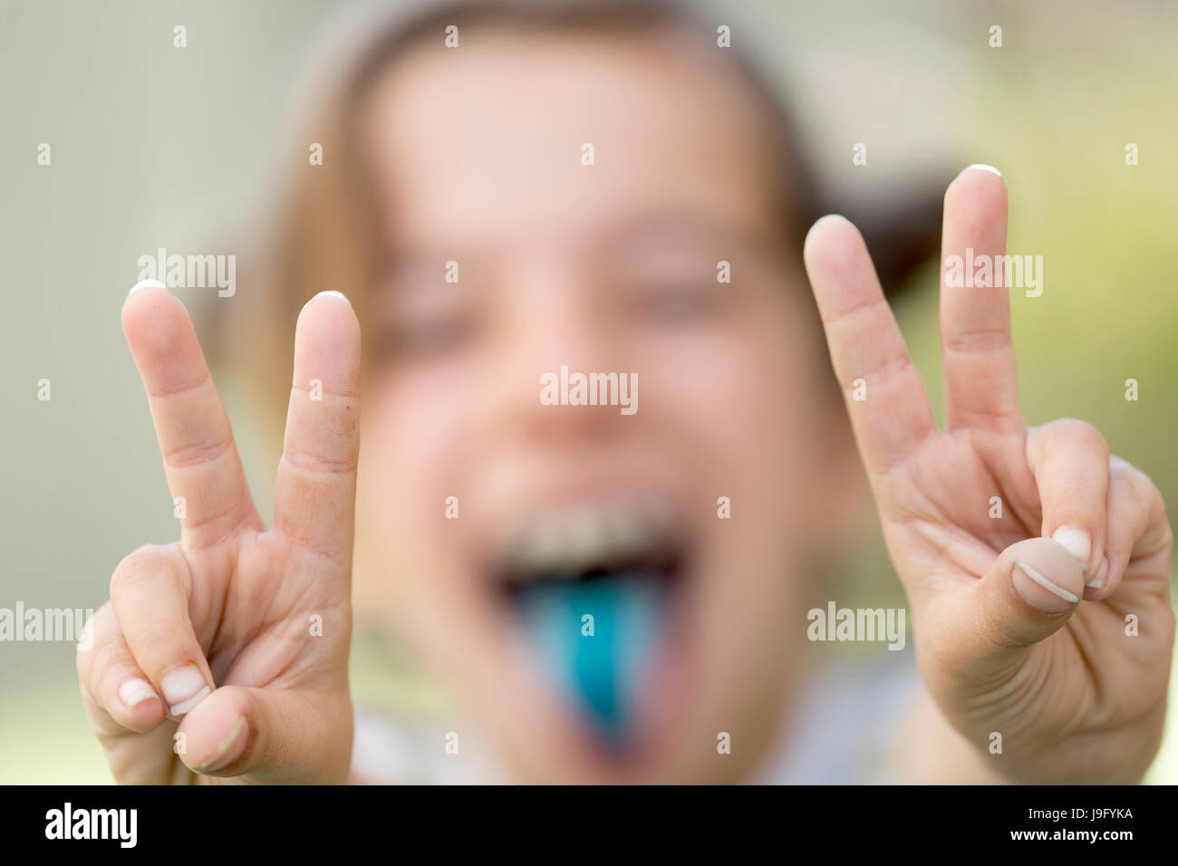 Girl with focused fingers and unfocused face. Horizontal shot with ...