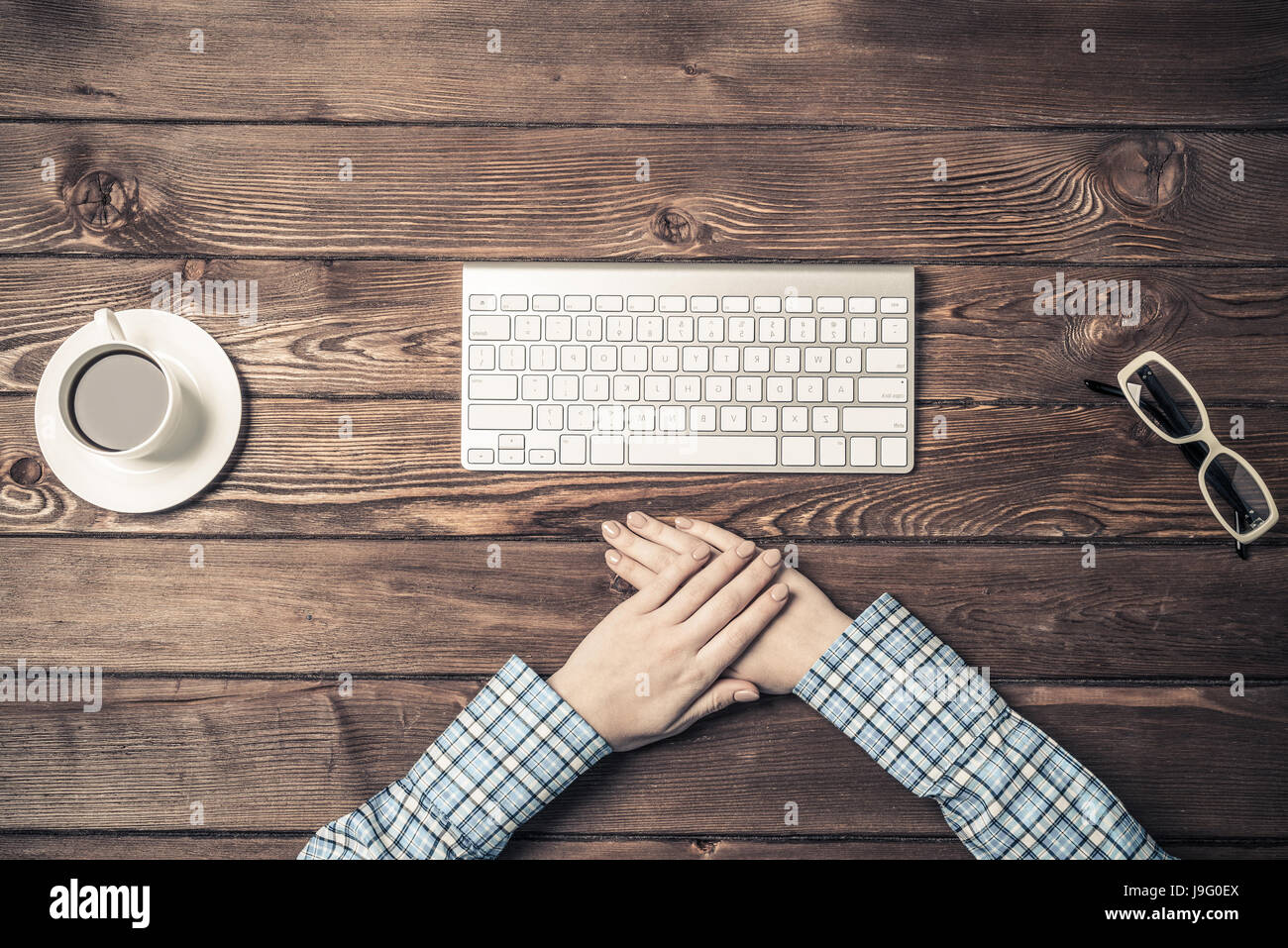 Top view of woman sitting at table with hands folded Stock Photo - Alamy