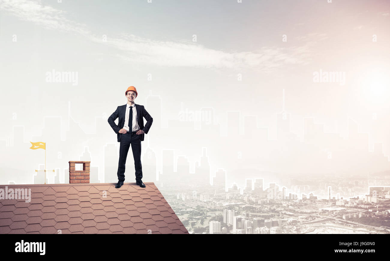 Engineer man standing on roof and looking away. Mixed media Stock Photo ...