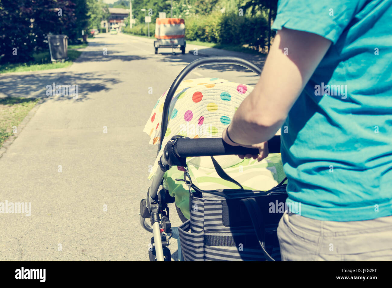 Casual dressed mother pushing a baby stroller Stock Photo - Alamy