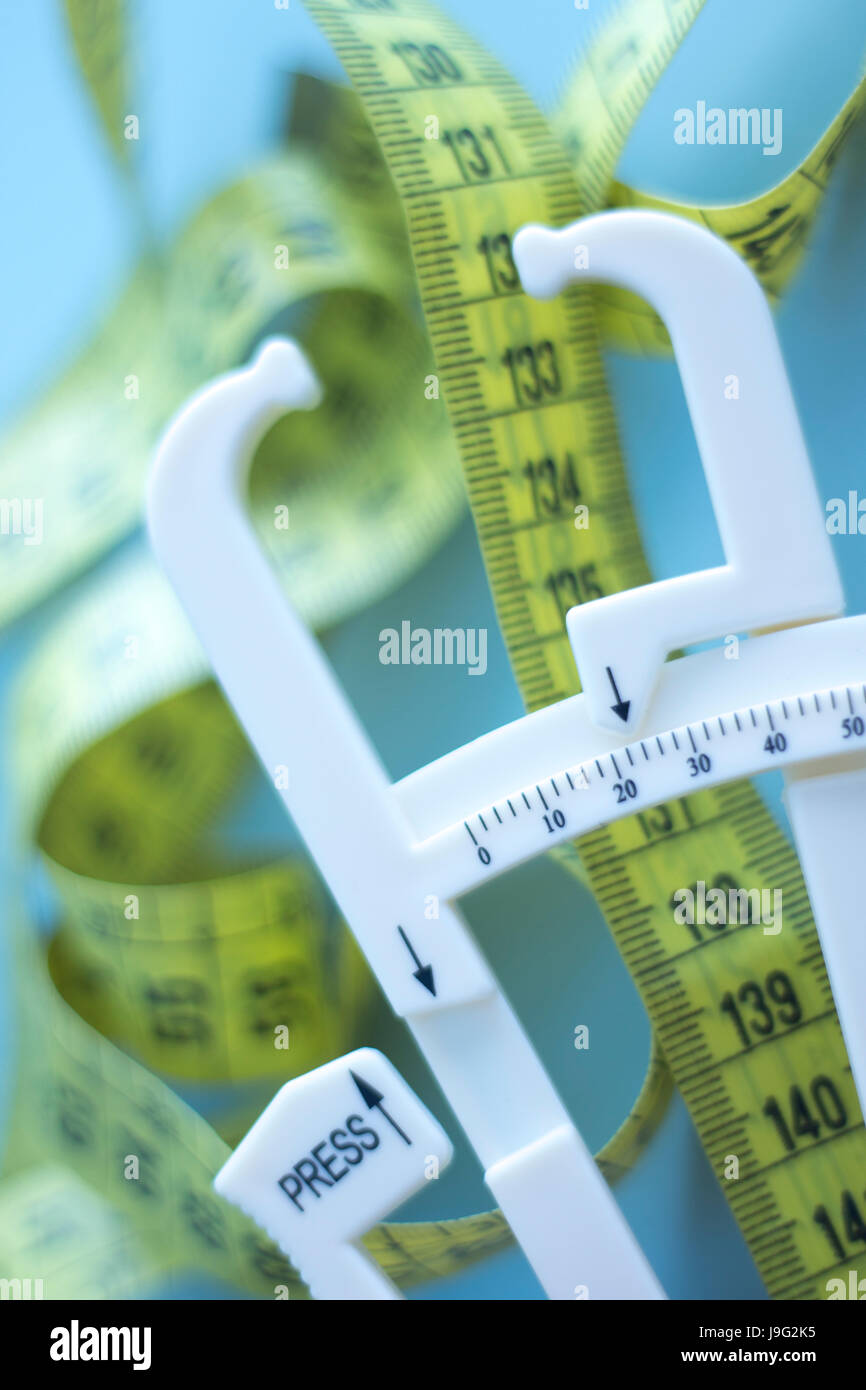 Fat caliper and measuring tape used to measure waistline, bodyfat ...