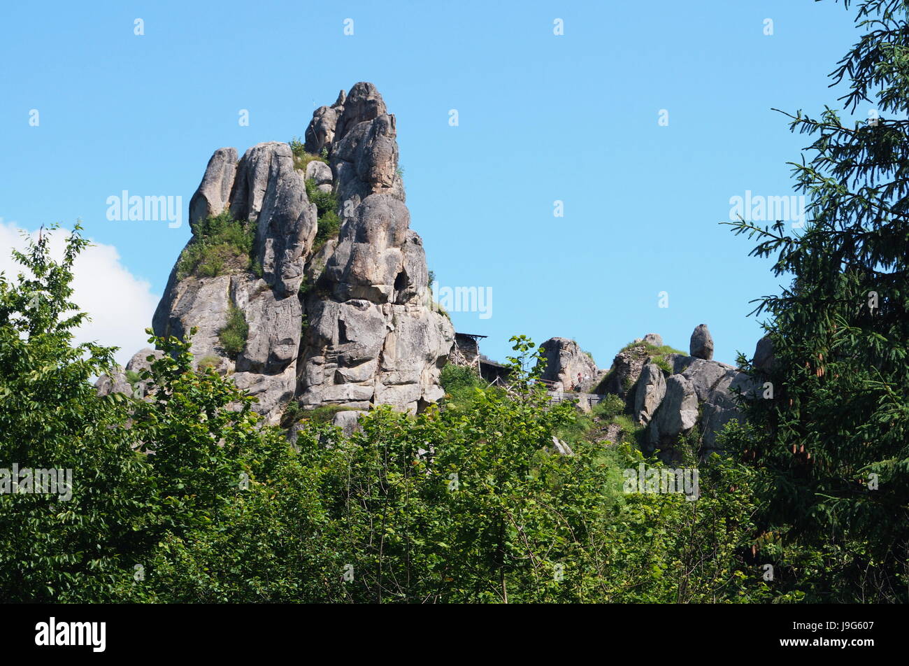 High stone rock in a green forest under a blue sky Stock Photo - Alamy