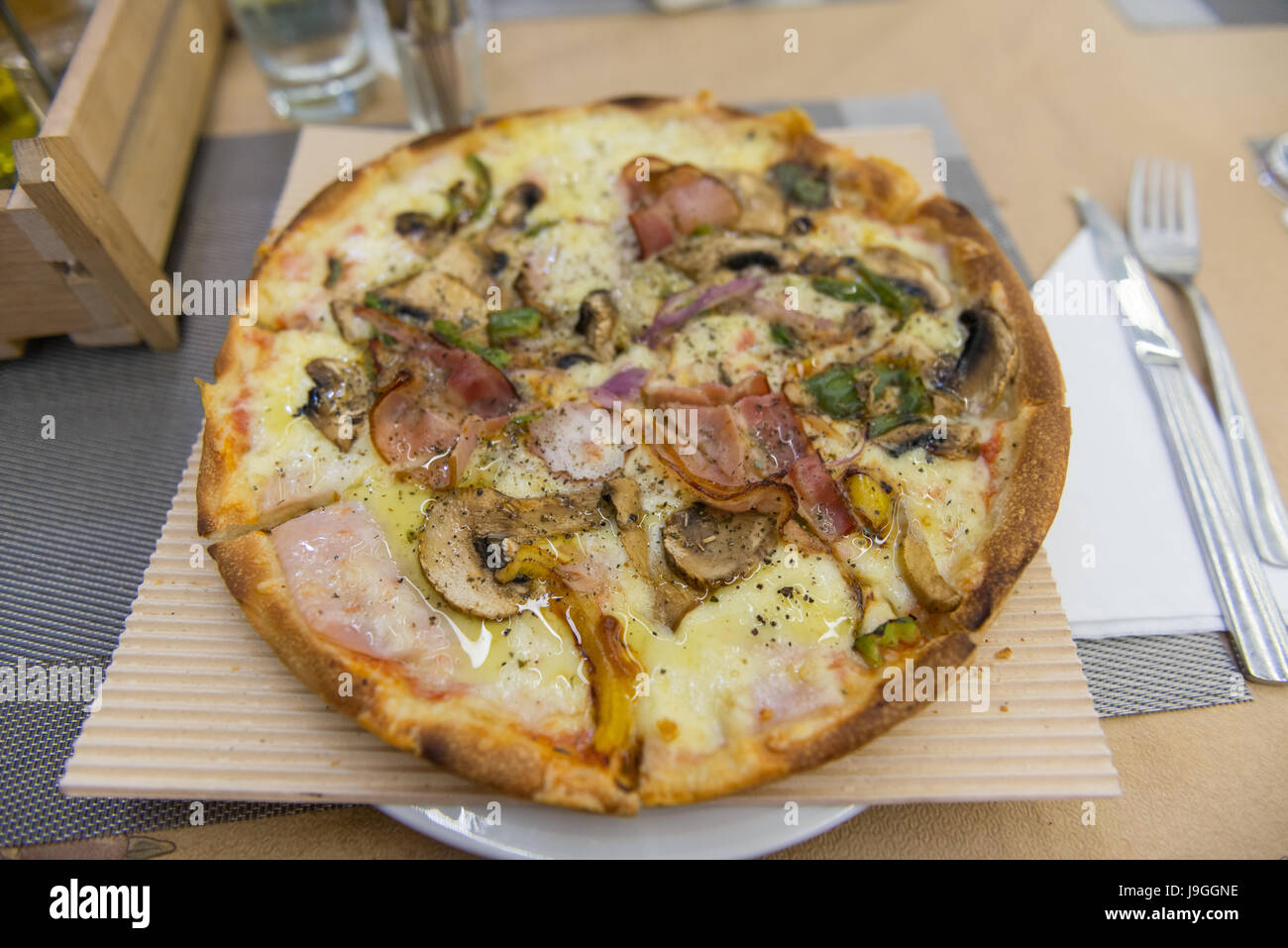 Large round pizza with topping on table Stock Photo - Alamy