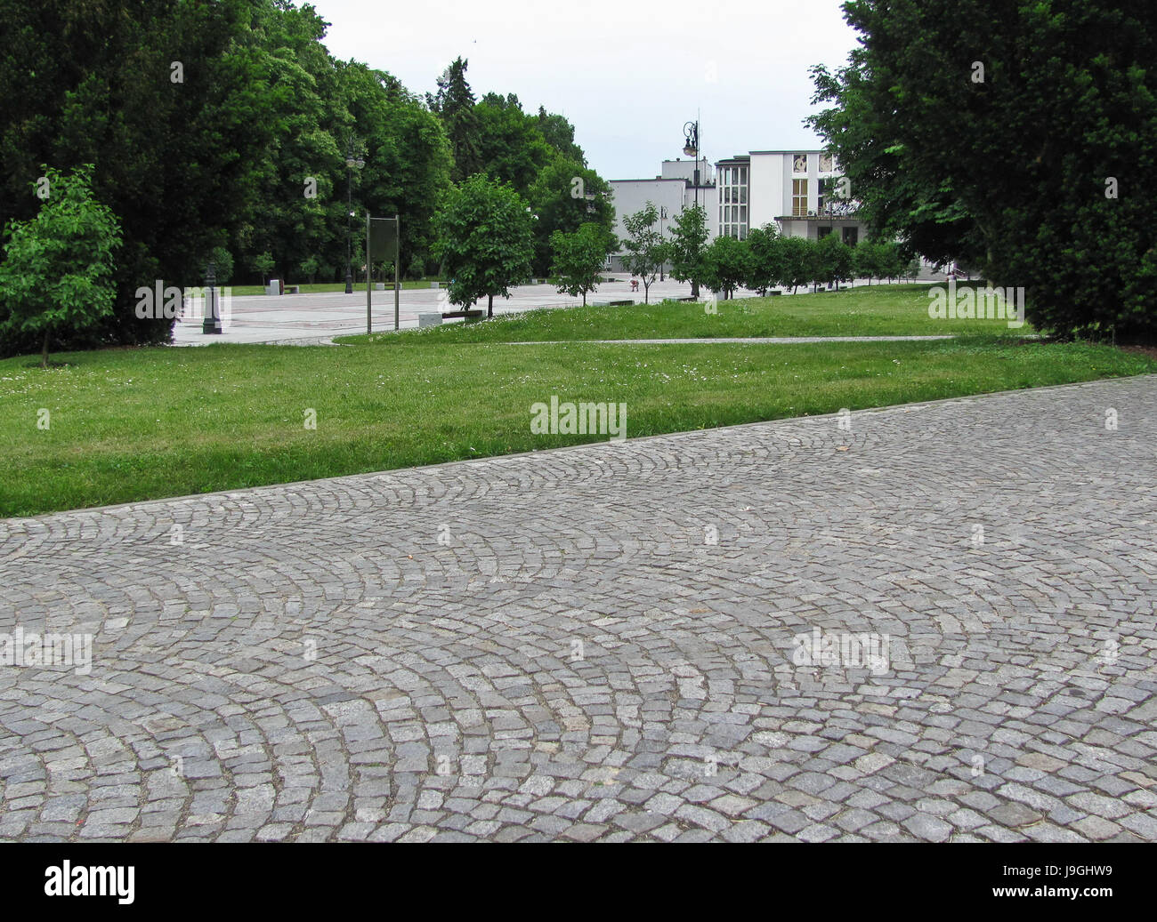 A pedestrian path, a lawn and a building on the horizon Stock Photo - Alamy