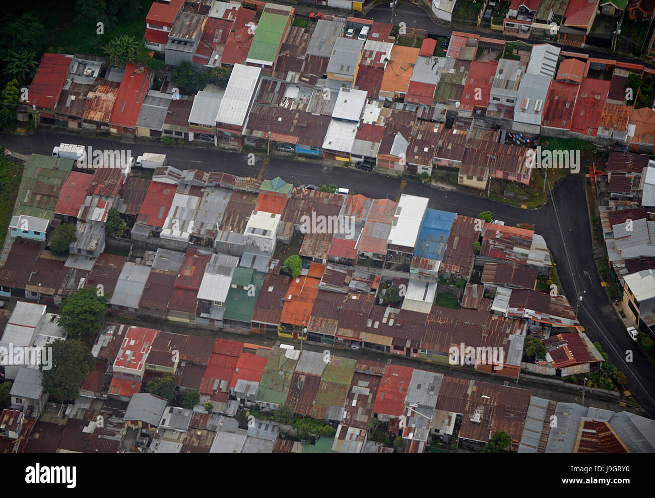 An aerial view of the rusted tin roofs of a community in San José ...