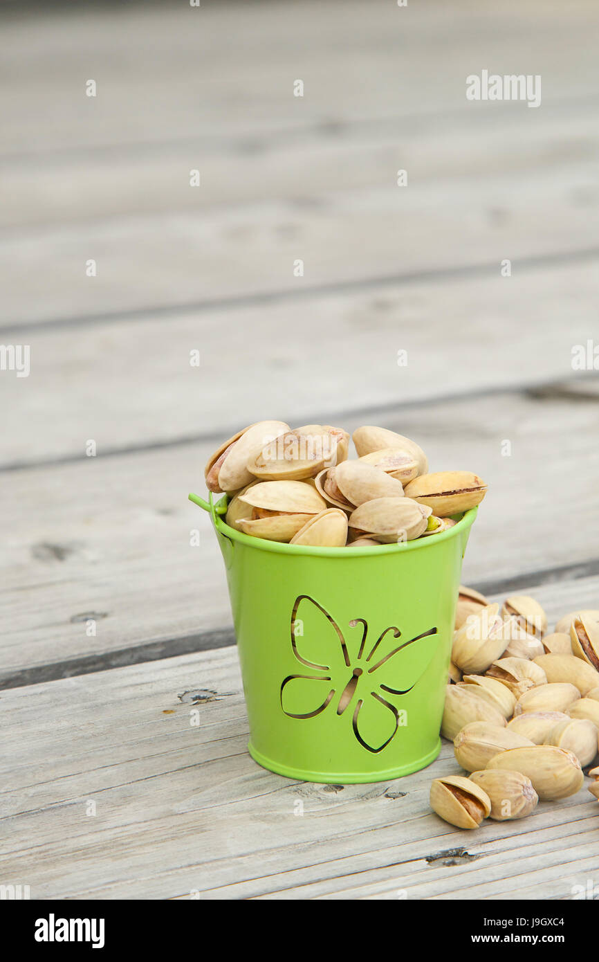 Pistachio nuts in a green decorative bucket Stock Photo - Alamy
